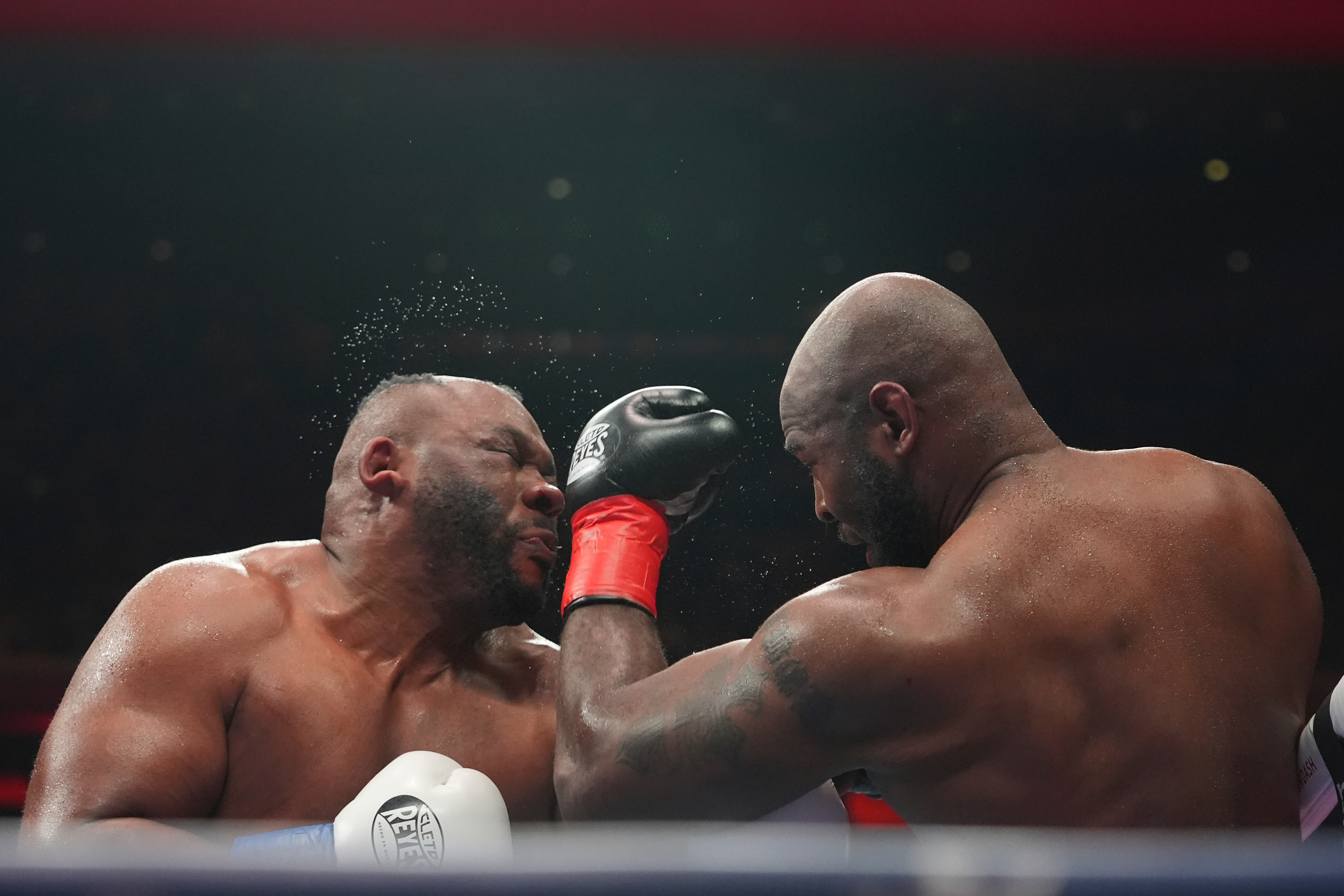Boxer Jarrell Miller has his hairpiece knocked upward by a punch, then ...